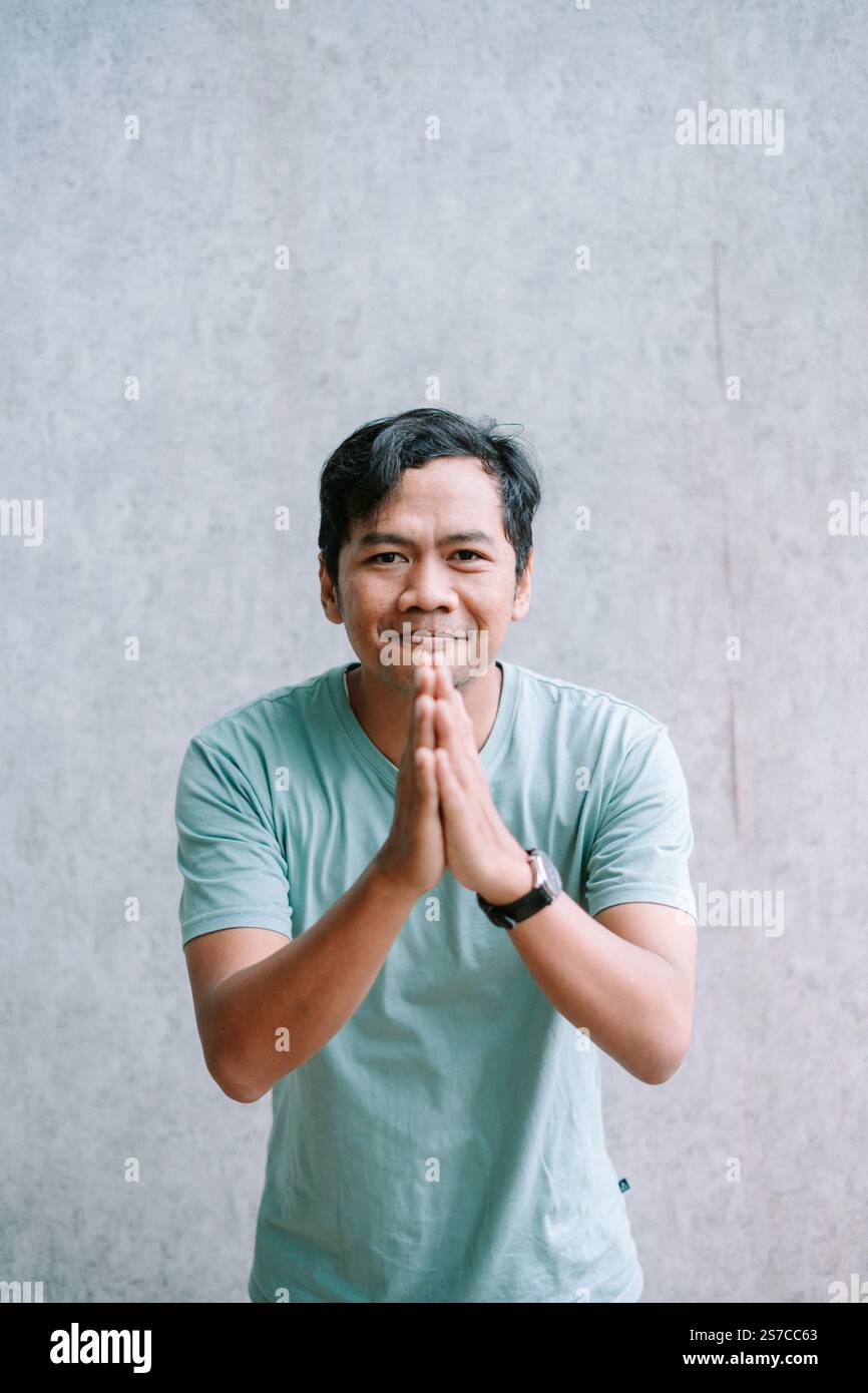 Man showing a respectful greeting with hands together Stock Photo - Alamy