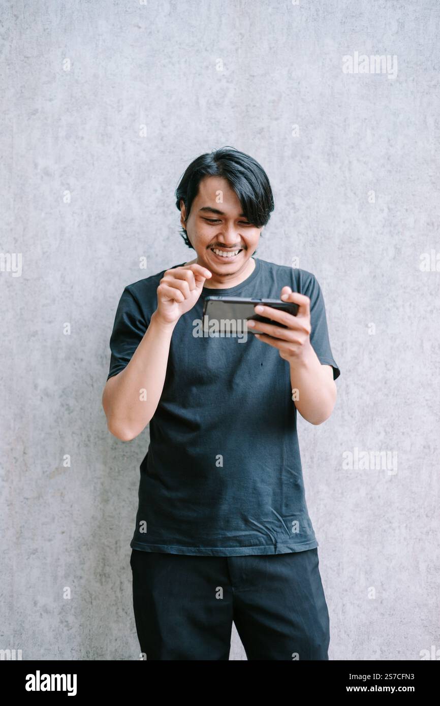 Man celebrating a win while playing a mobile game Stock Photo - Alamy