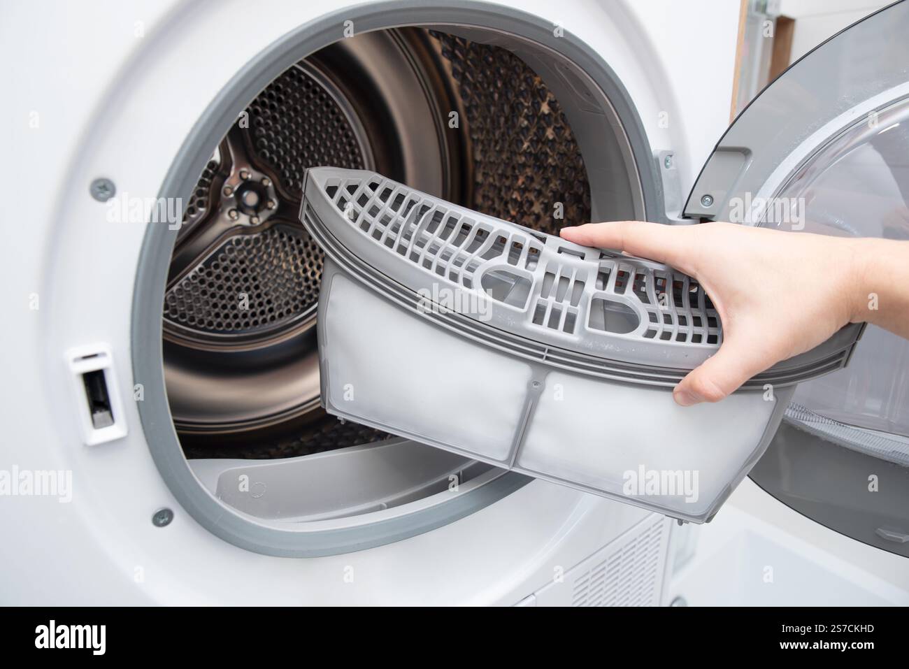 Cleaning dryer lint filter. Laundry dryer in utility room Stock Photo ...