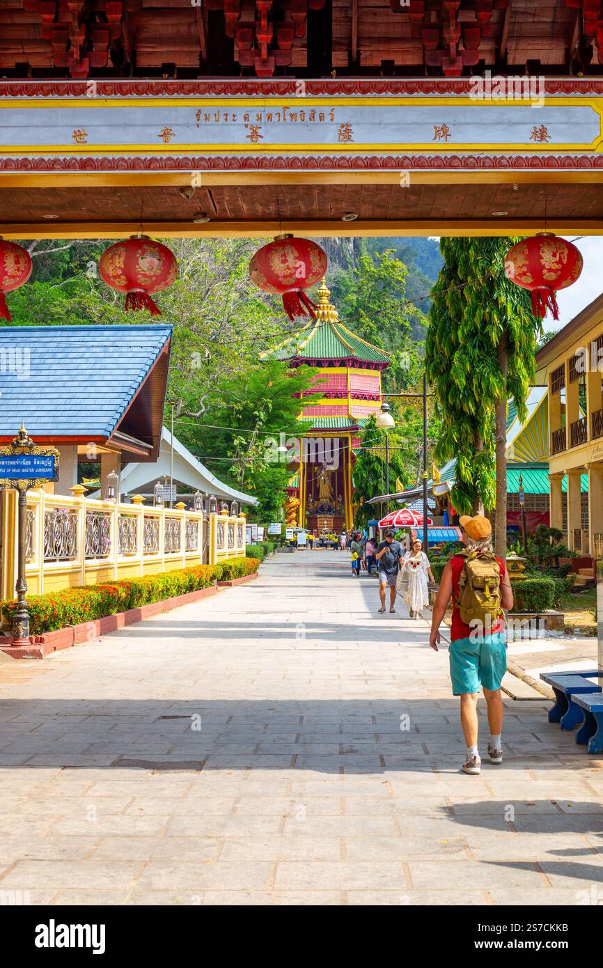 A backpacker walks through the colorful gates of the Buddhist Tiger ...