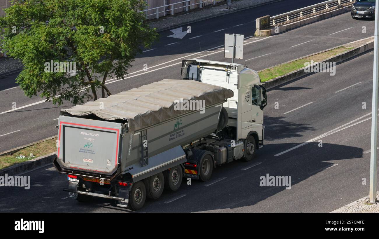 Covered dump semi trailer truck driving on highway under sunlight Stock ...