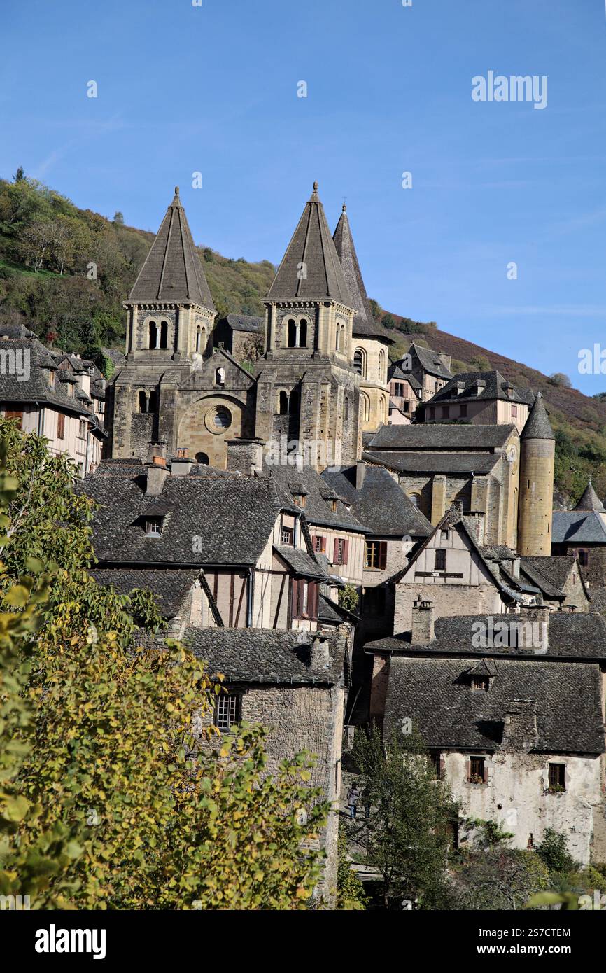 In Conques, France, medieval buildings stand tall among lush greenery ...