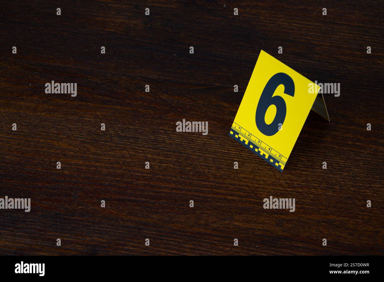 Yellow crime scene evidence marker number 6 on the floor in the room ...