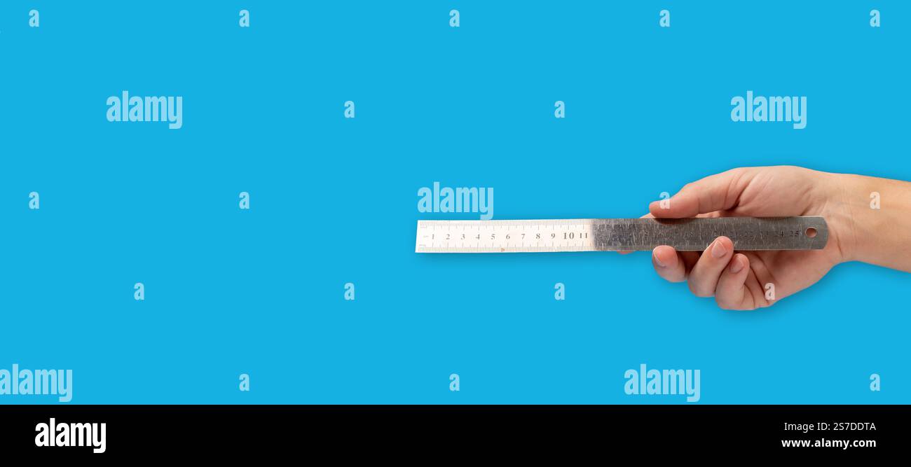 Hand holding metal ruler on blue background with copy space Stock Photo ...