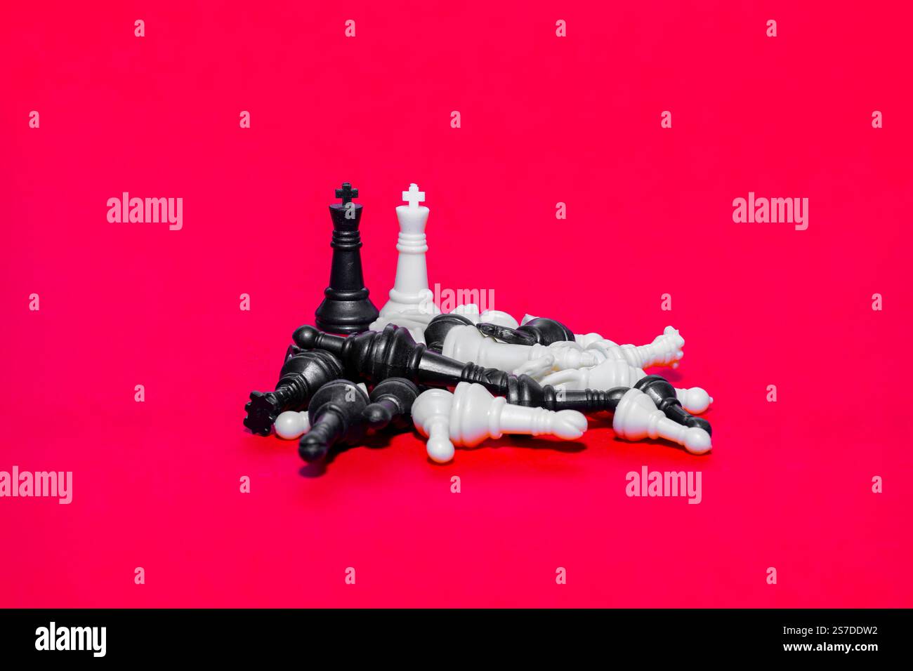 Black and white chess pieces are stacked in a chaotic arrangement, set ...