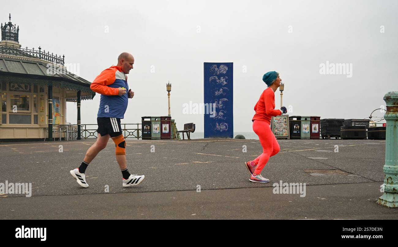 Brighton UK 19th January 2025 - Runners pass by the Kiss Wall sculpture ...