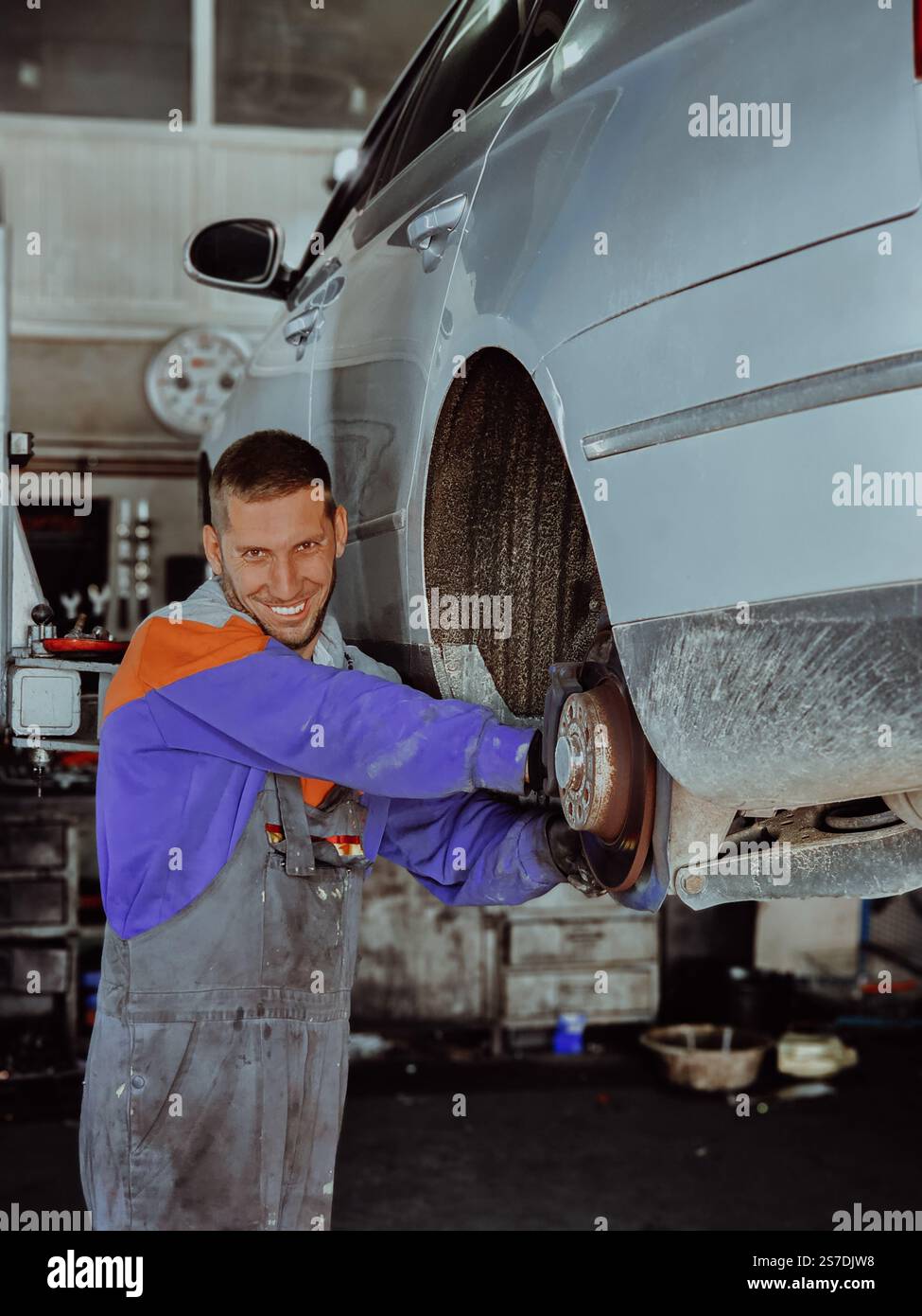 An automotive mechanic in his workshop, diligently repairing the brakes ...