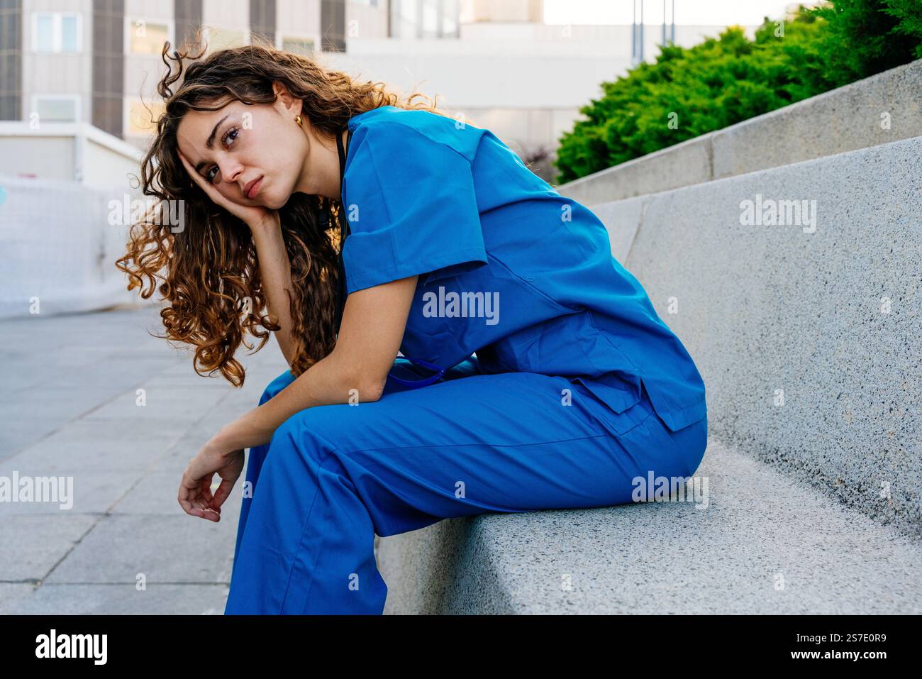 Beautiful young nurse wearing hospital blue uniform strolling in the ...