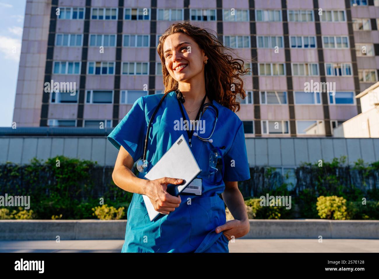 Beautiful young nurse wearing hospital blue uniform strolling in the ...