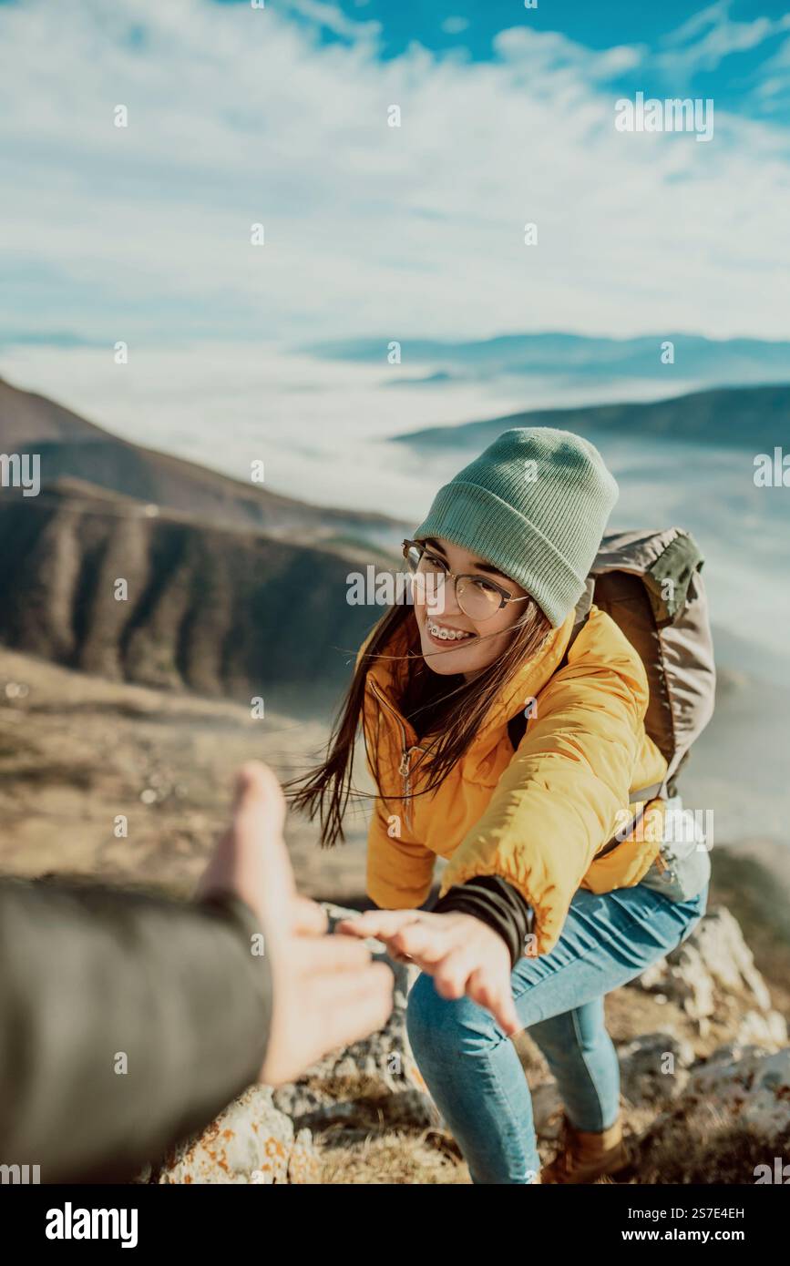 People helping each other hike up a mountain at sunrise Stock Photo - Alamy