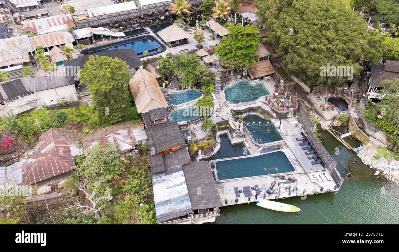 Drone shot capturing cascading geothermal pools at Mount Batur, where traditional Balinese ...