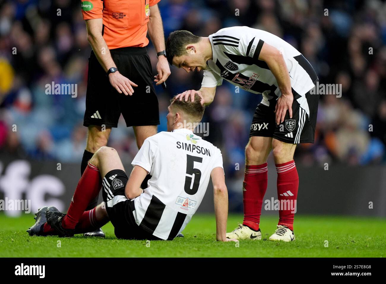 Fraserburgh's Kieran Simpson sits on the pitch as his team mates checks ...