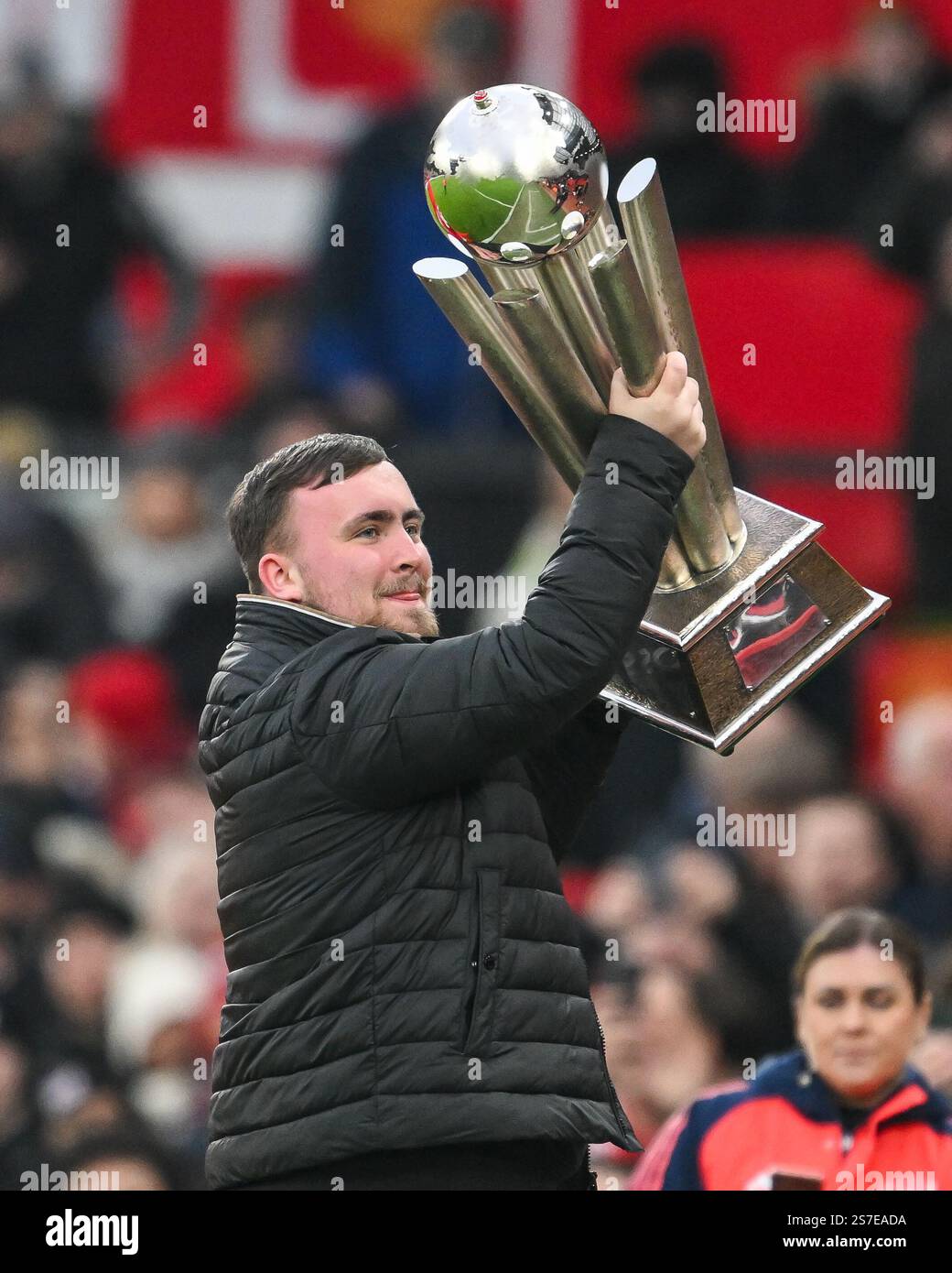 Luke Littler parades the PDC World Championship trophy at half time ...