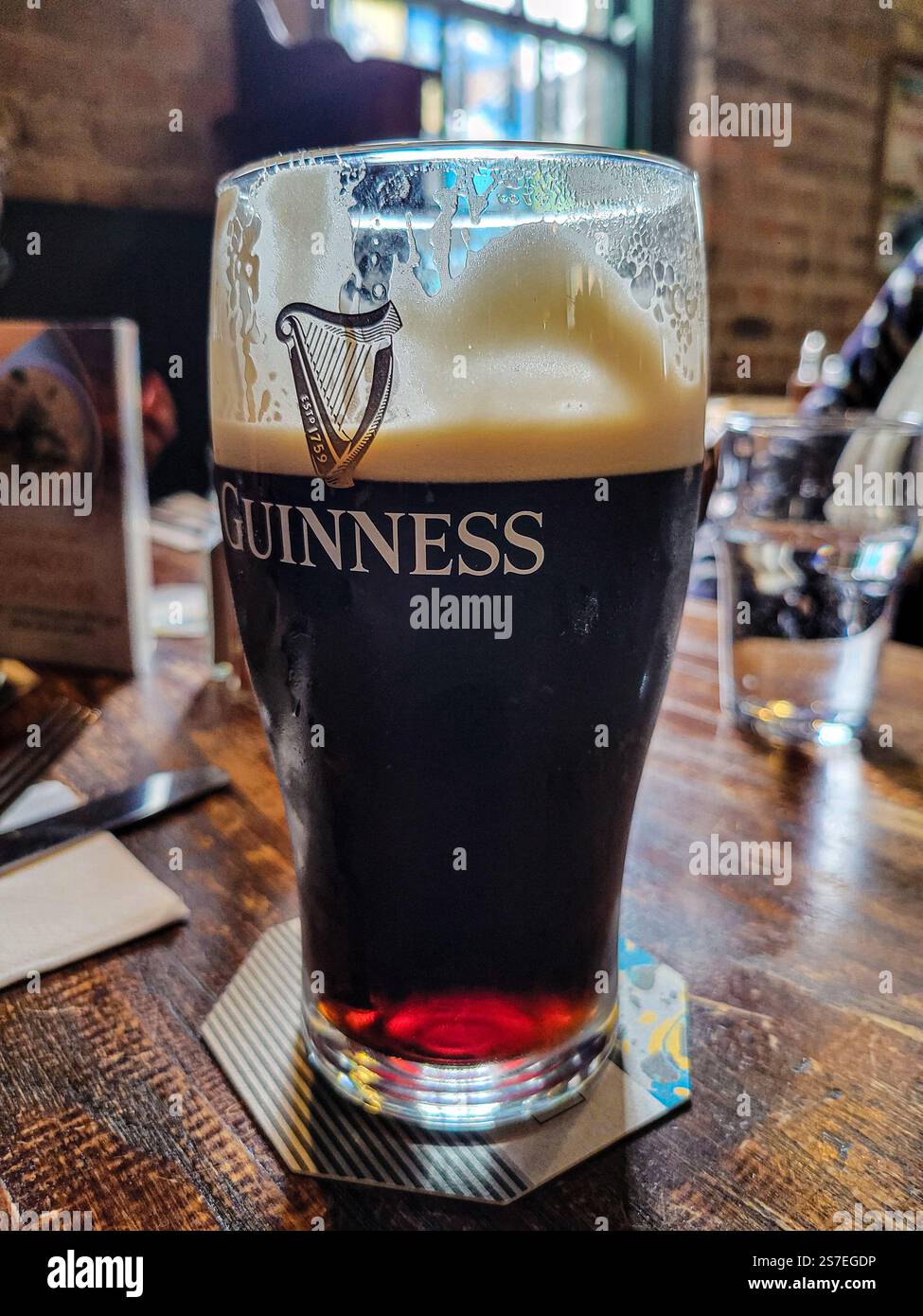 Pint of Guinness in a Cozy Pub Stock Photo - Alamy