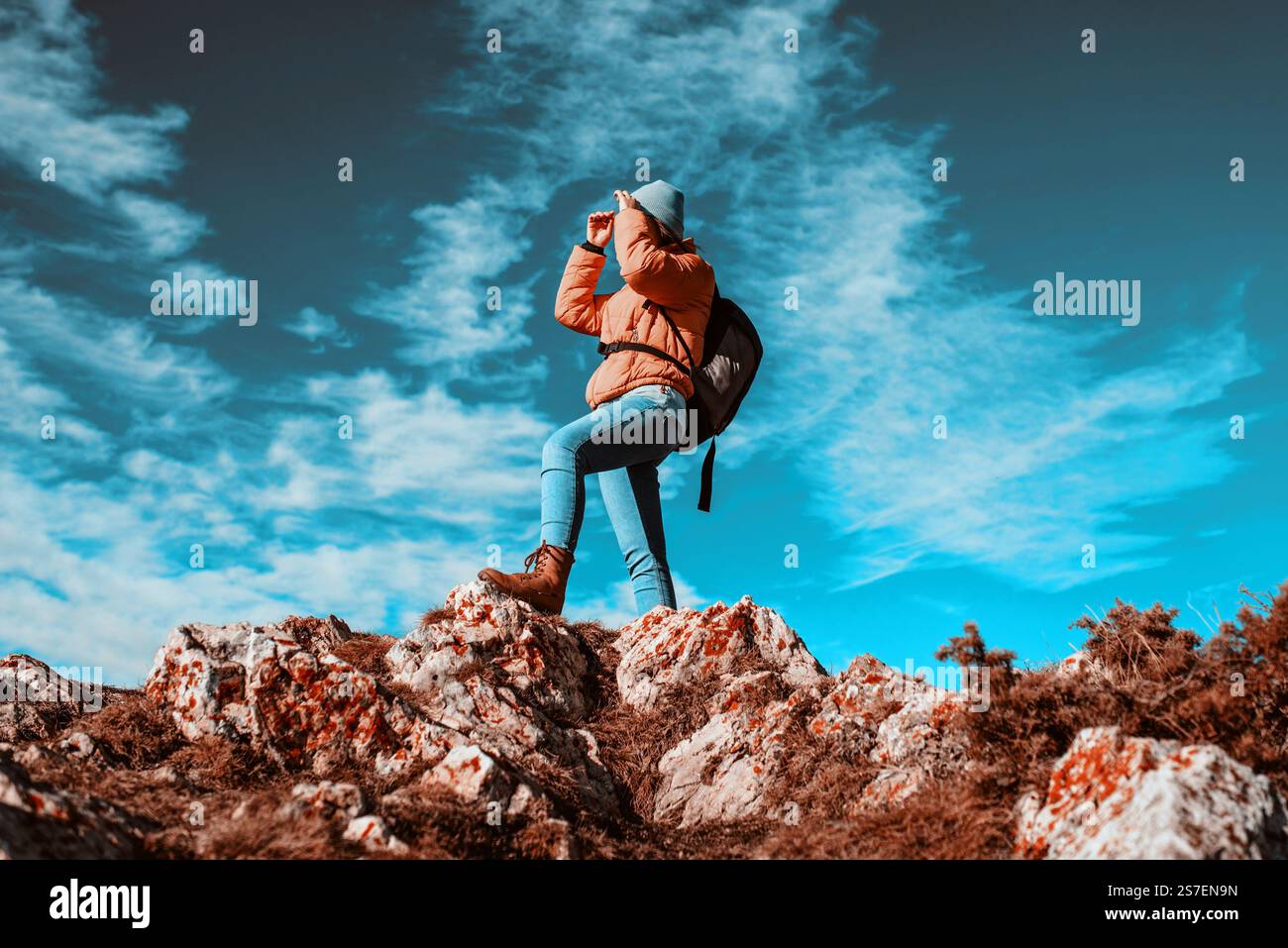 Cheering woman backpacker enjoy the view on sunrise mountain top cliff ...