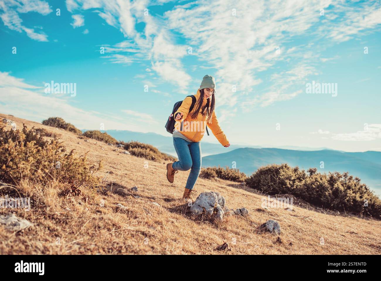 Cheering woman backpacker enjoy the view on sunrise mountain top cliff ...