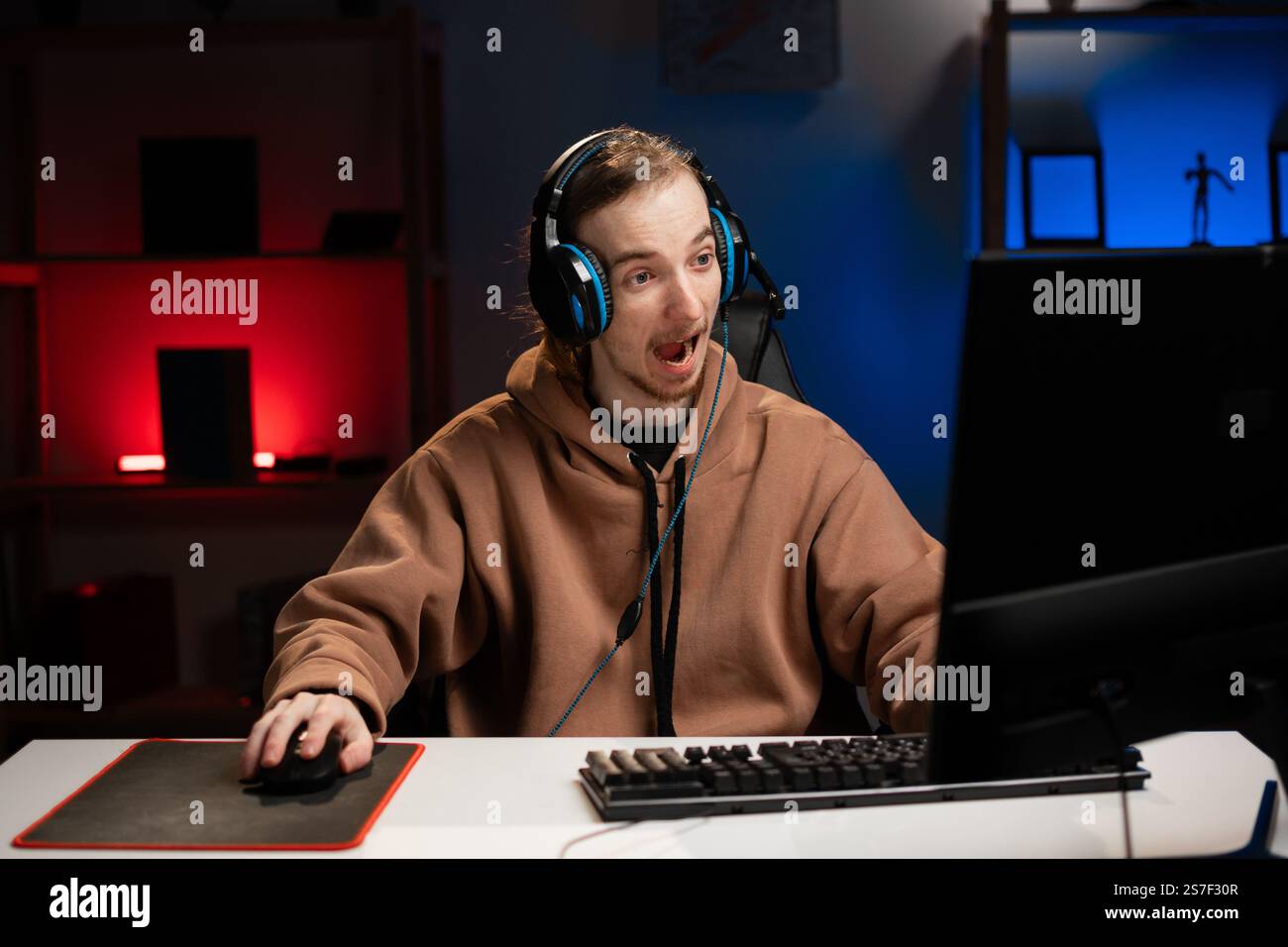 Man pro gamer wear headphones playing an online game in neon room at ...