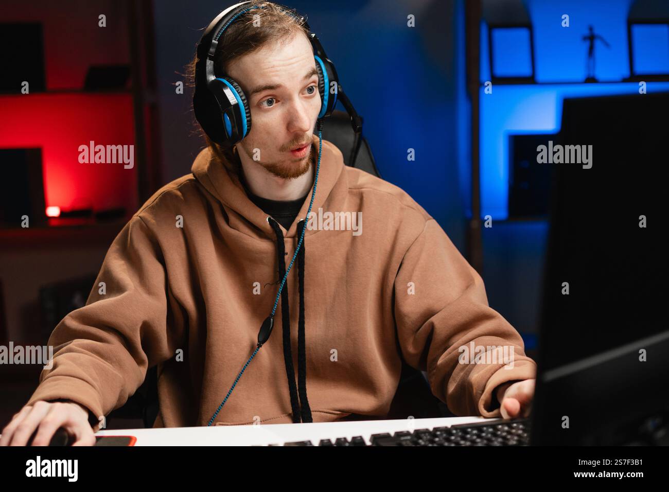 Shocked gamer playing computer games sitting in the living room at ...