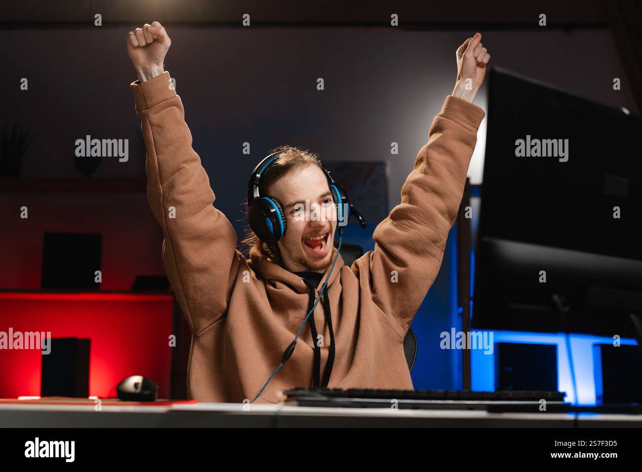 Successful gamer playing computer games sitting in the living room at ...