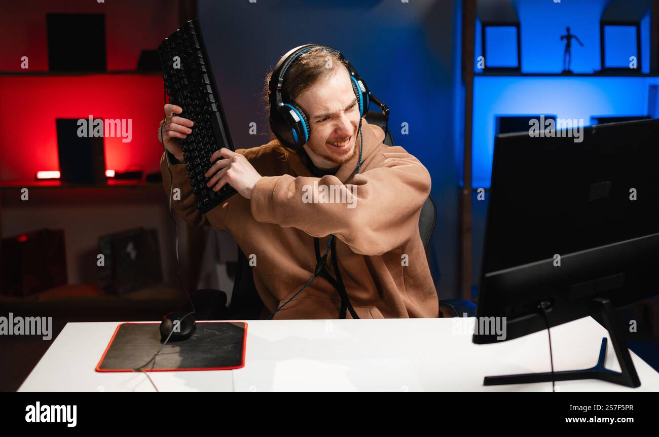 Frustrated gamer streamer during live stream, angrily raising keyboard ...
