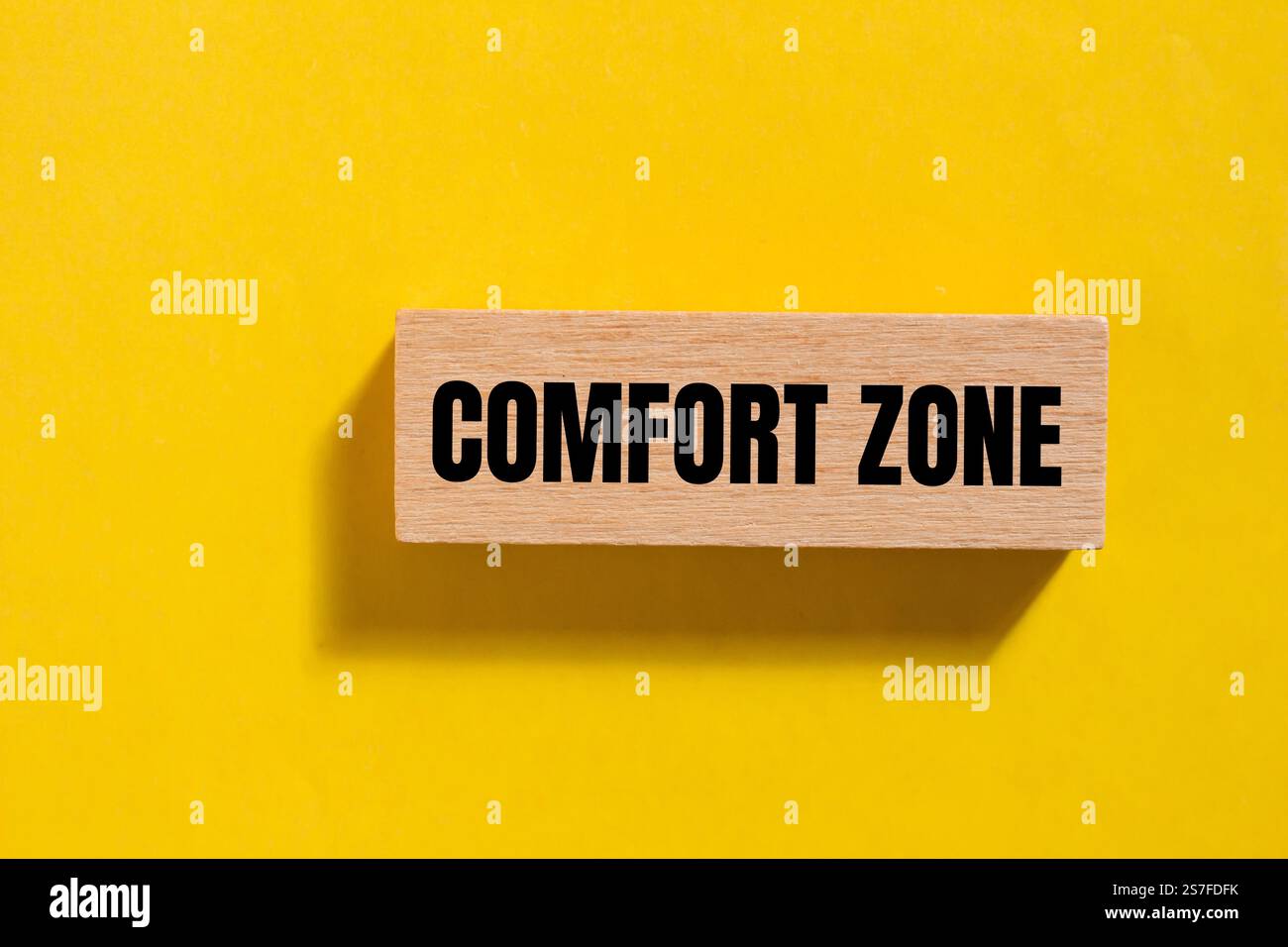 Comfort zone message written on wooden block with yellow background. Conceptual comfort zone ...