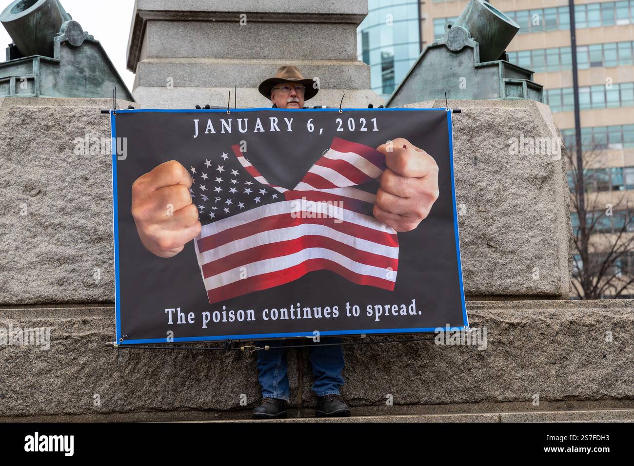 A protestor stands on the Admiral Farragut Monument in Farragut Square ...