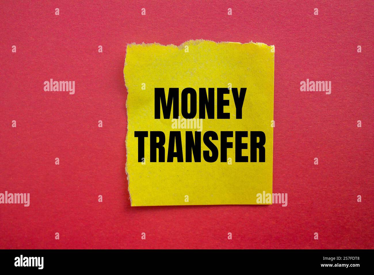 Money transfer message written on ripped torn yellow paper piece with red background. Conceptual ...