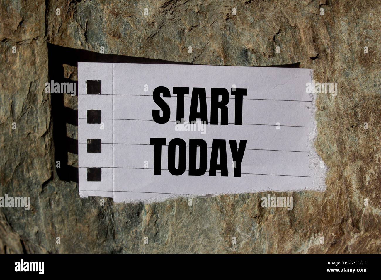 Start today message written on ripped torn paper piece with stone background. Conceptual start ...
