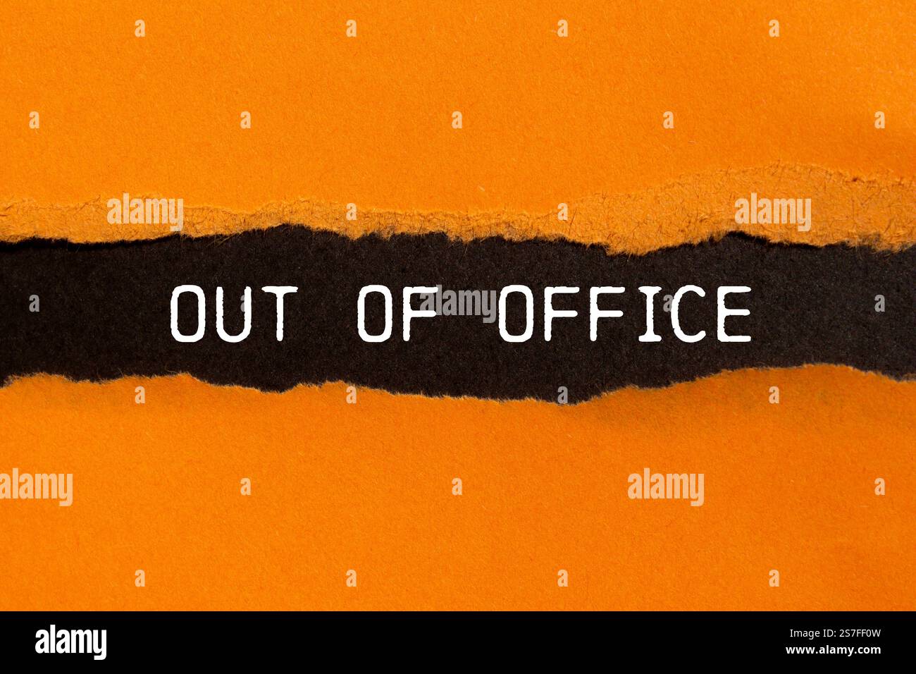 Out of office message written on ripped torn orange paper with black ...
