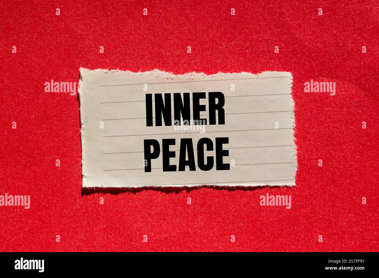 Inner peace message written on ripped torn paper piece with red background. Conceptual inner ...