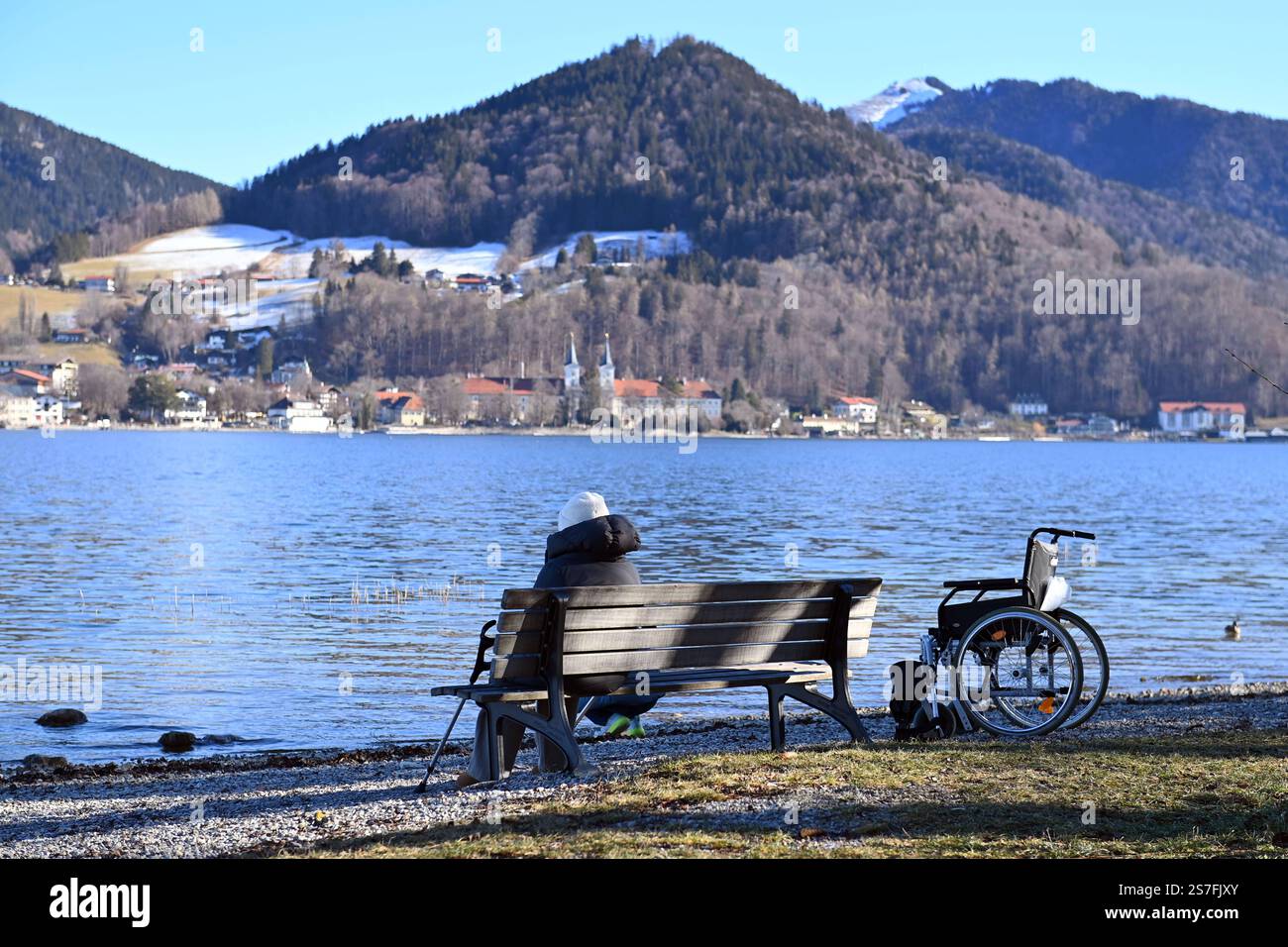 Frau mit Behinderung sitzt auf einer Bank am Ufer vom Tegernsee.Ihr ...