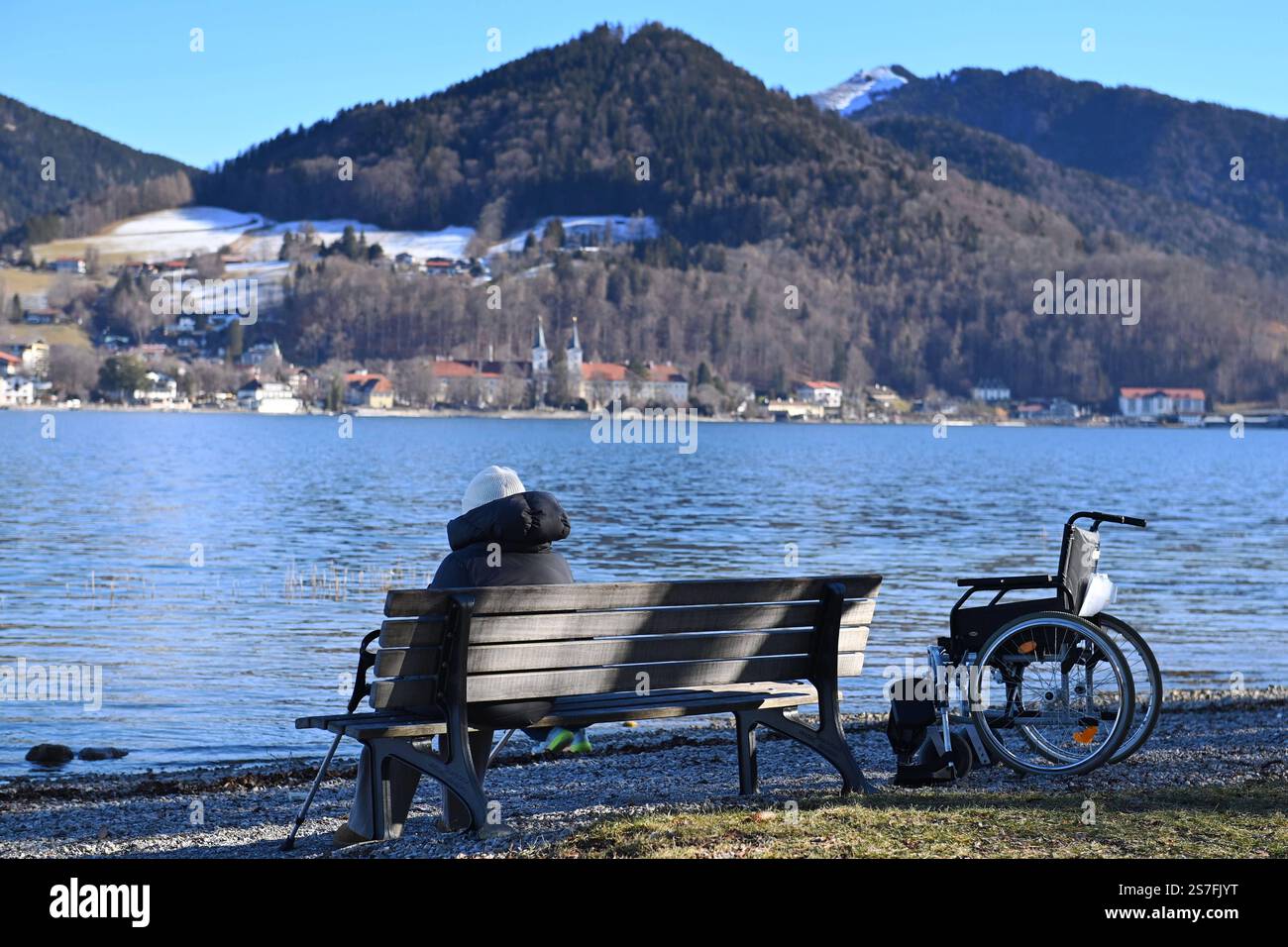 Frau mit Behinderung sitzt auf einer Bank am Ufer vom Tegernsee.Ihr ...