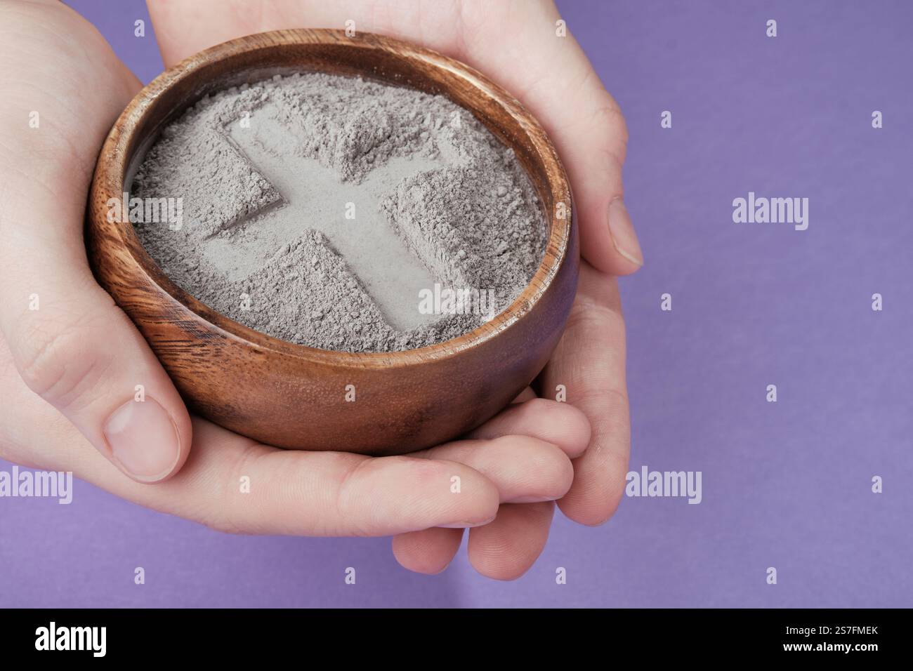 Hands with gray ash cross on purple background. Ash Wednesday Stock ...