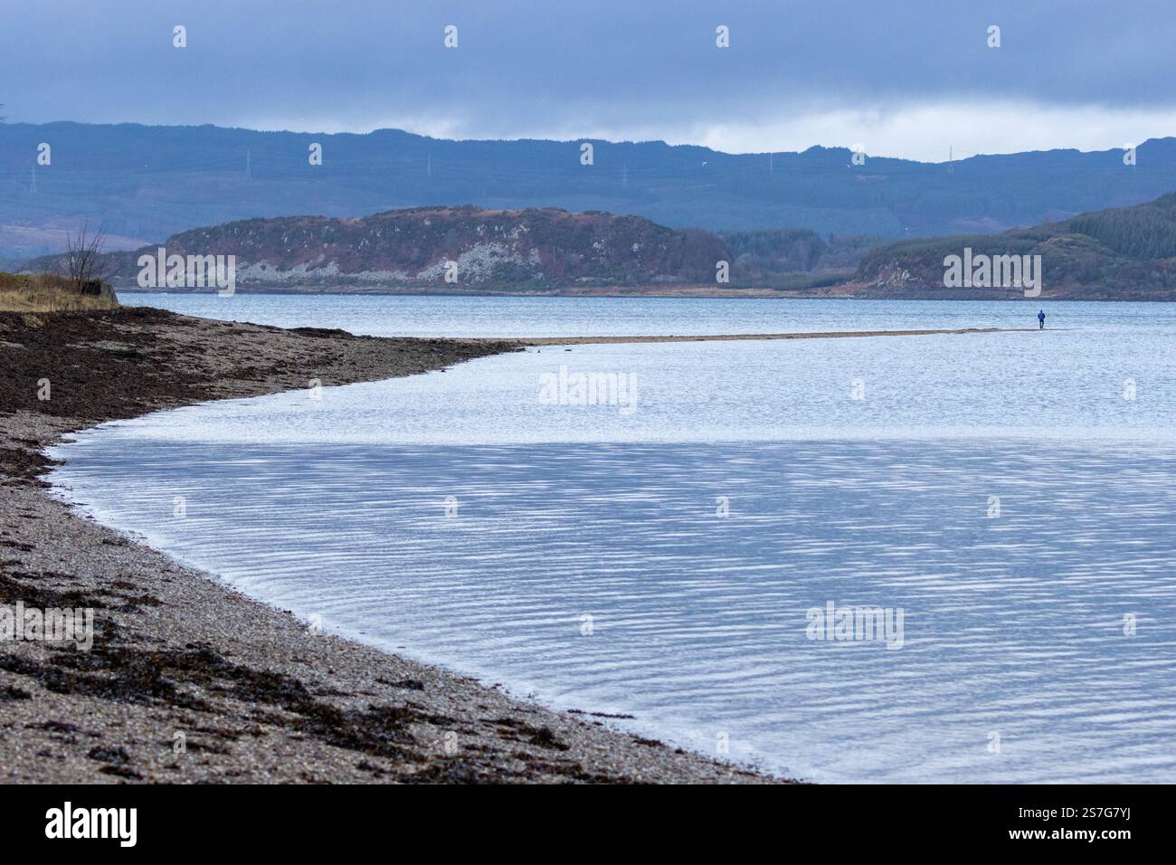 Lone person standing on a spit of land at Otter Ferry on the Cowal ...