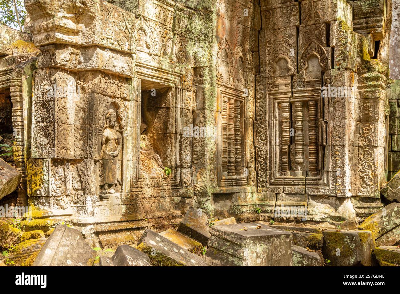 Ruined wall decorated with statues in ancient Ta Prohm temple lost in ...