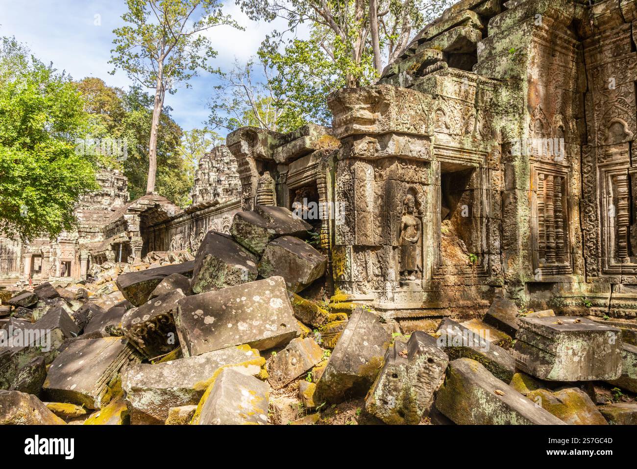 Ruined wall decorated with statues in ancient Ta Prohm temple lost in ...