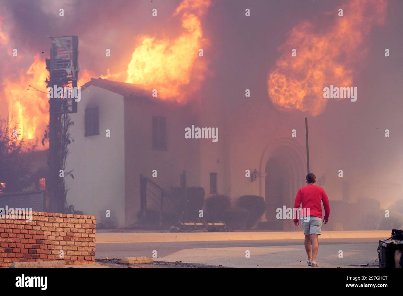 A man walks across from the burning Altadena Community Church during ...