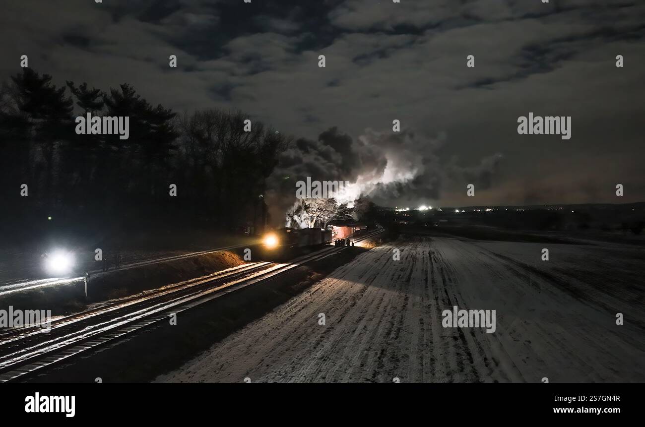 A train car is on fire next to snowy fields under a moonlit sky. Smoke ...