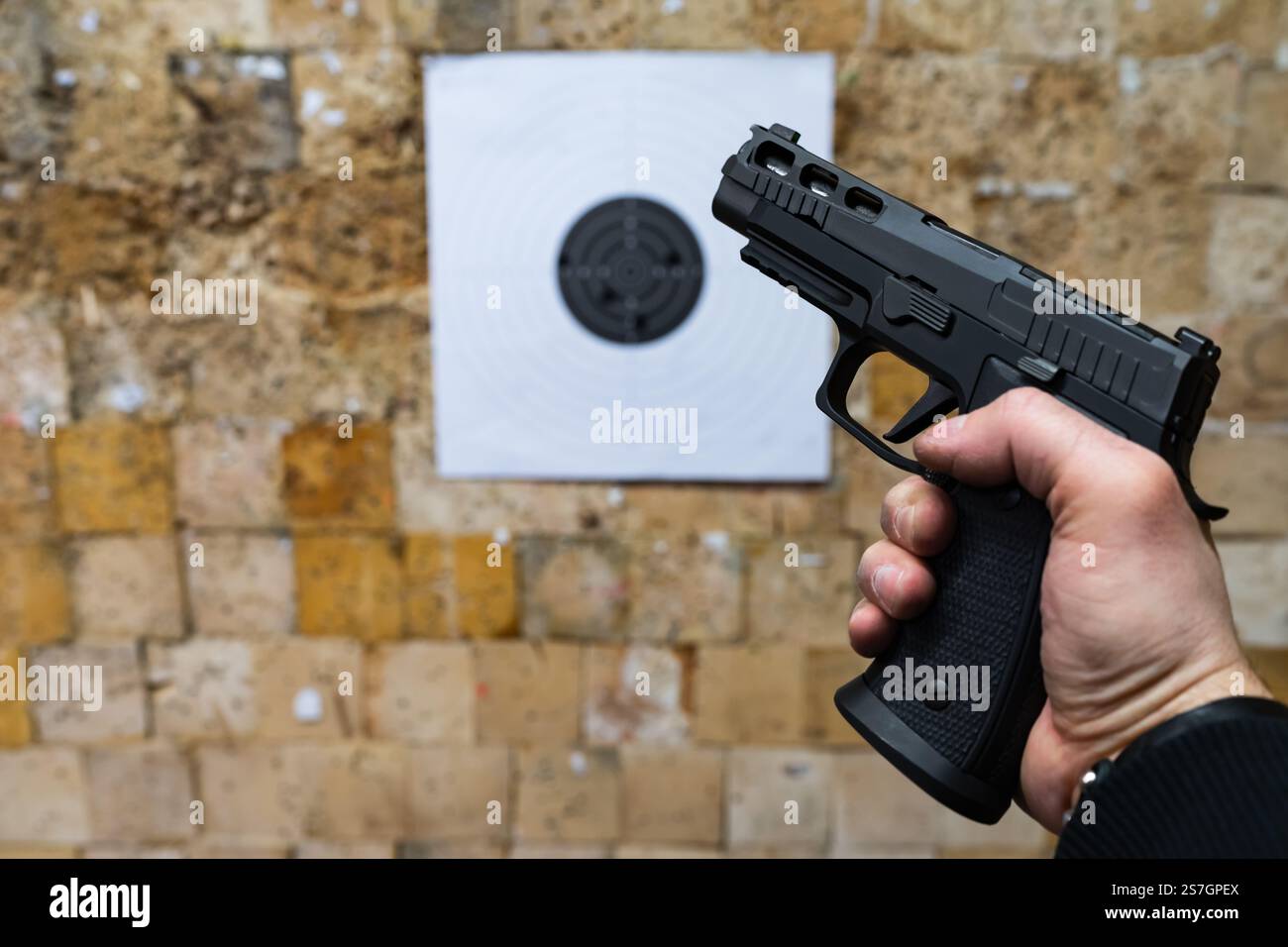 Shooting at a shooting range, a tactical pistol in the shooter's hand ...