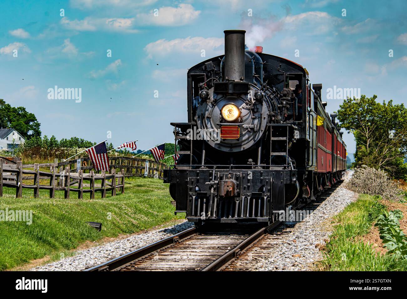 A vintage steam train moves along its tracks in a picturesque ...