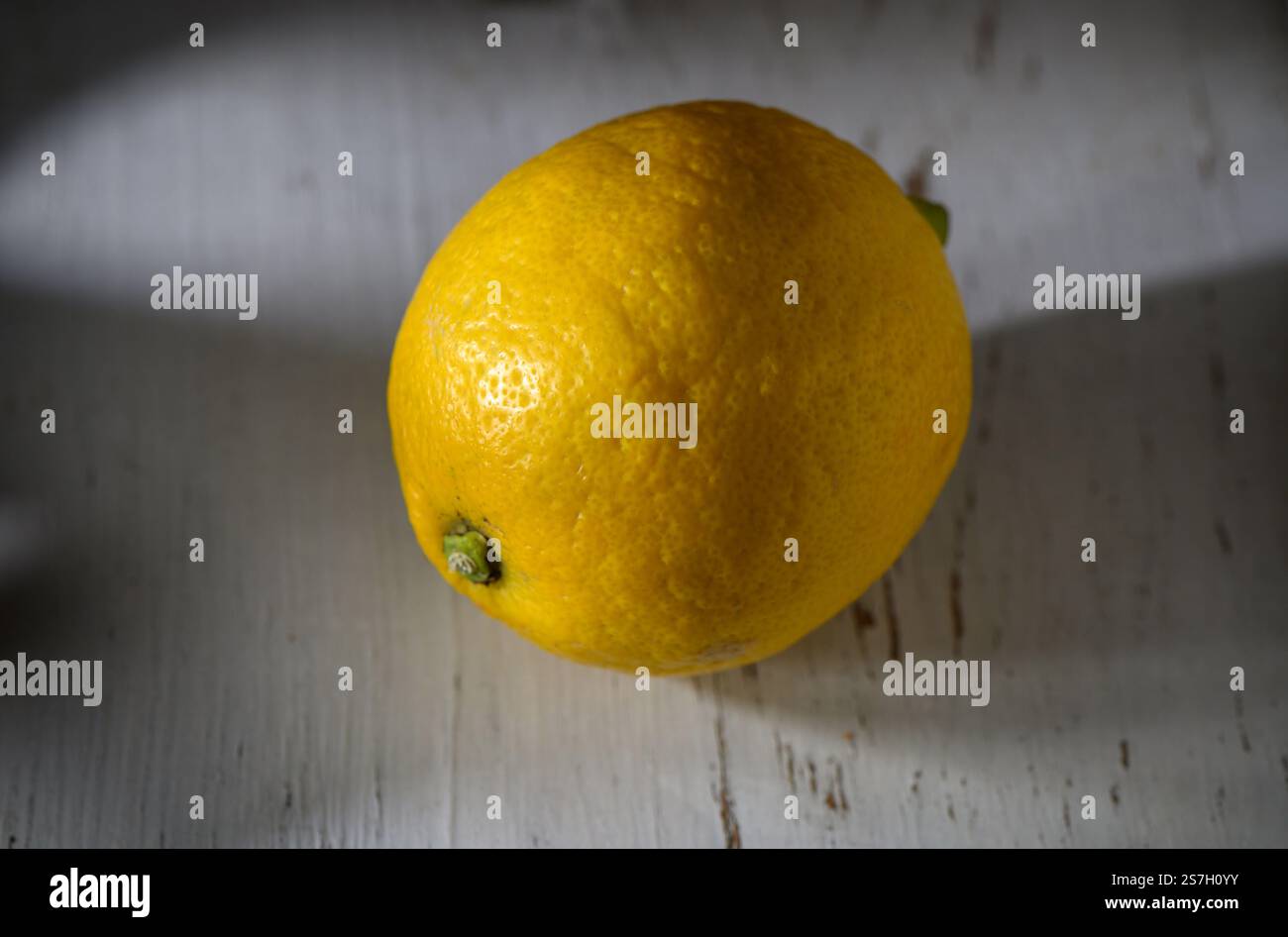 Golden lemon sits elegantly on weathered wood, showcasing its vibrant ...