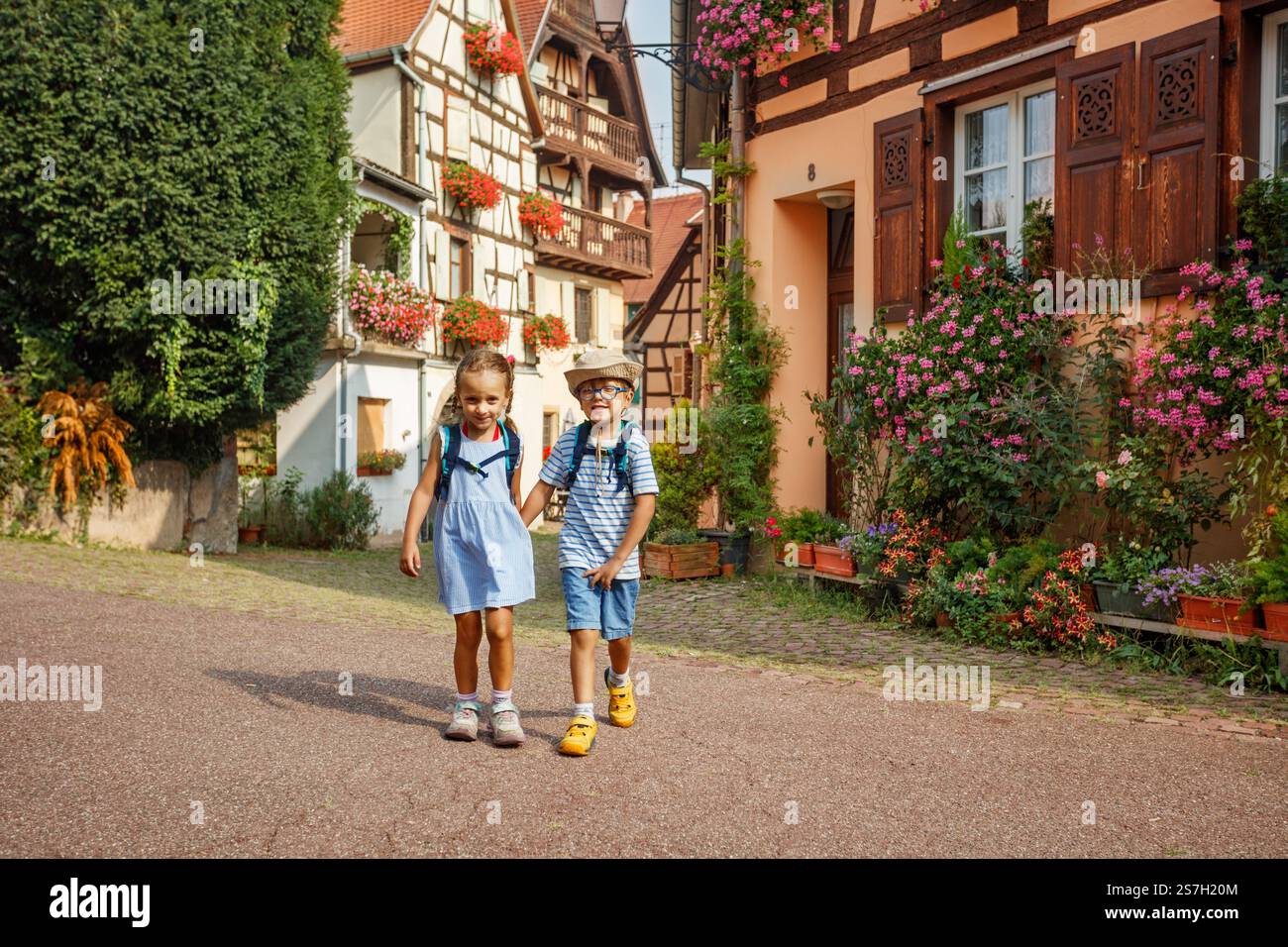 Charming village scene with kids walk past traditional homes Stock ...