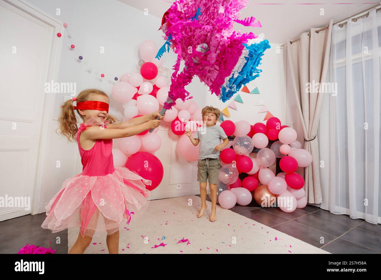 Birthday fun with a pink pinata and cheerful kids cheer jumping Stock ...