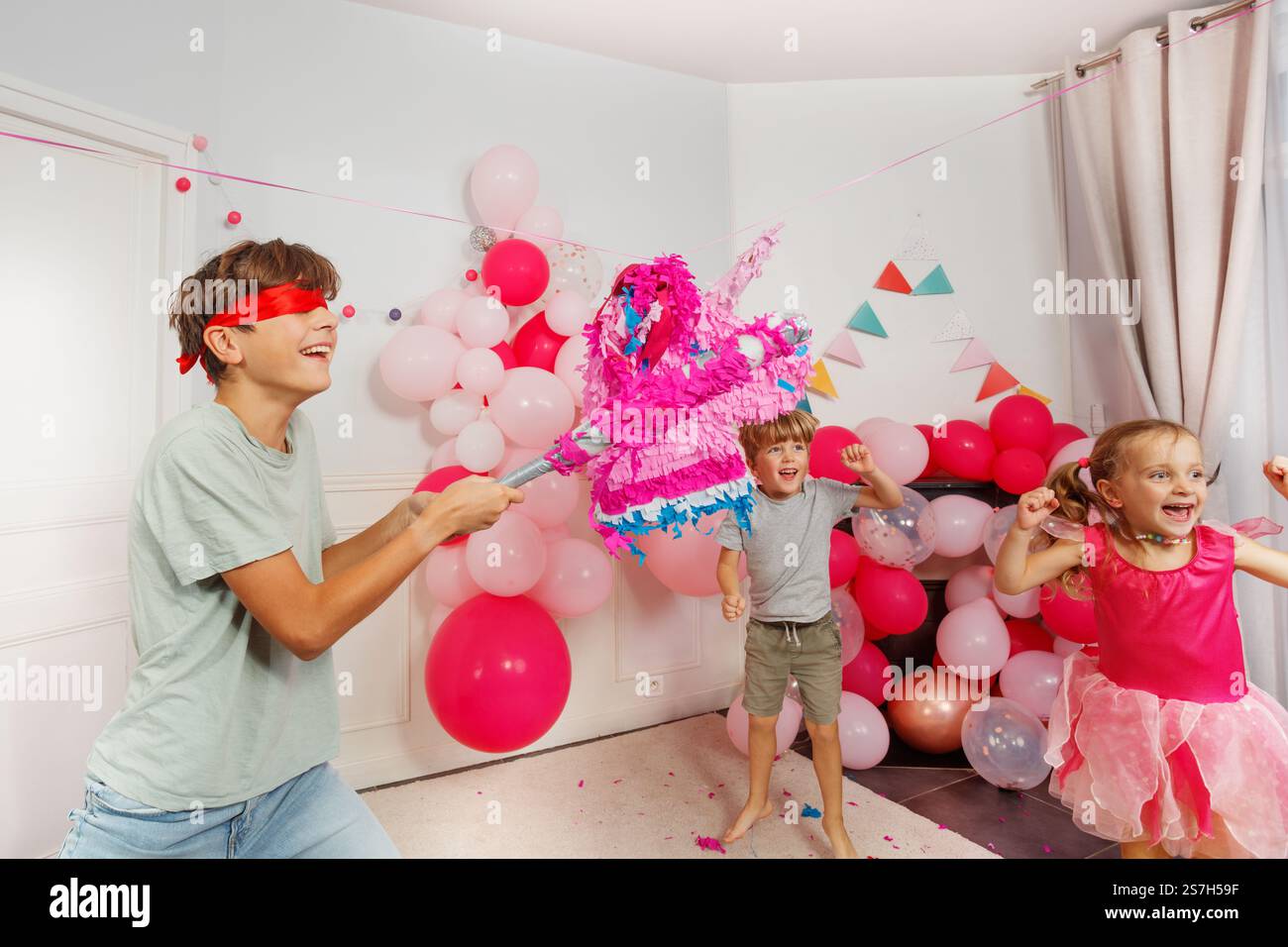 Party fun: children take turns hitting the pinata to get candies Stock ...