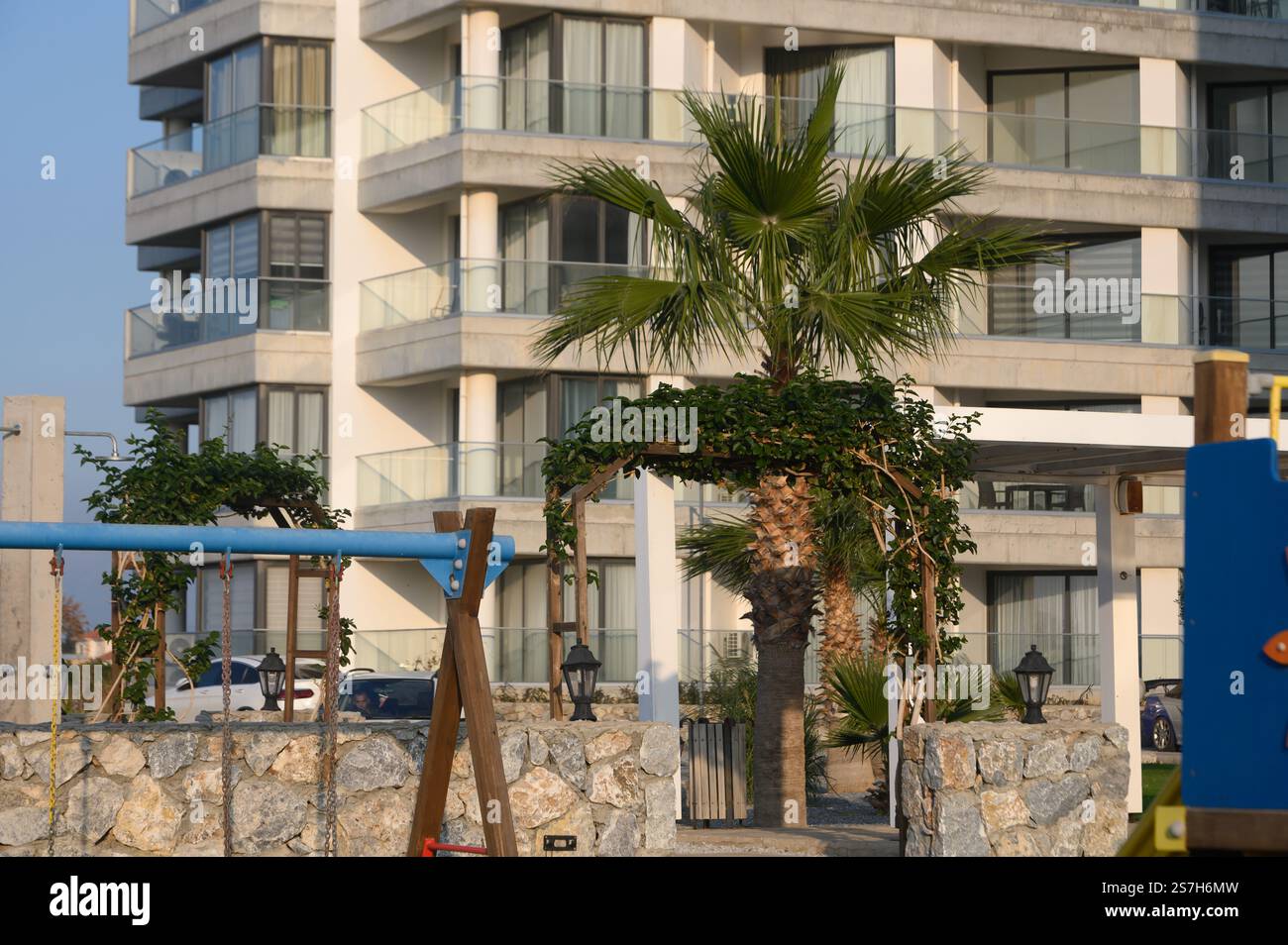 Palm trees sway gently by a modern building, overlooking a tranquil ...