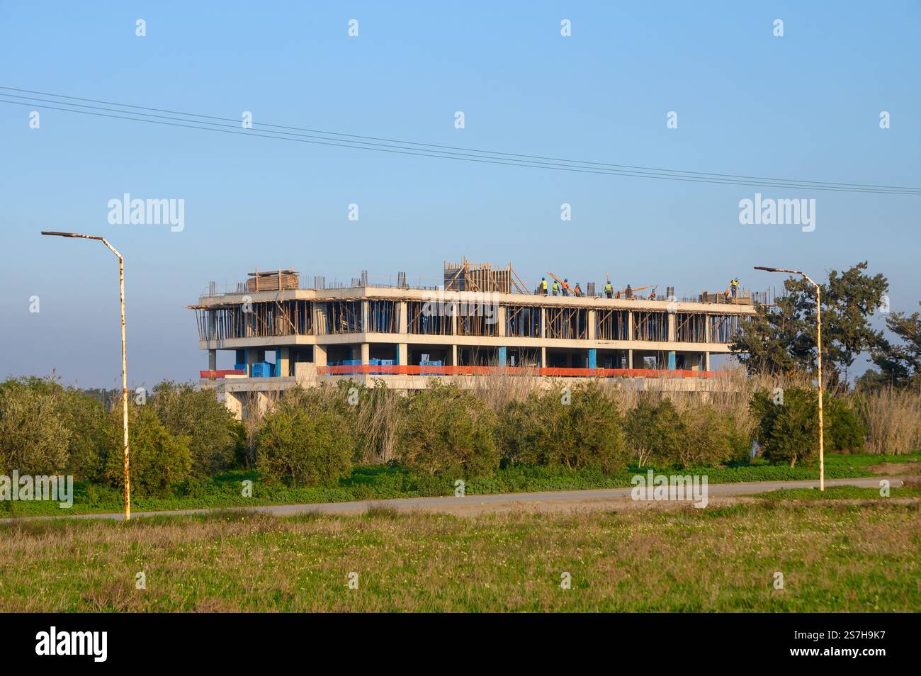 Workers are busy at a construction site for a new building surrounded ...