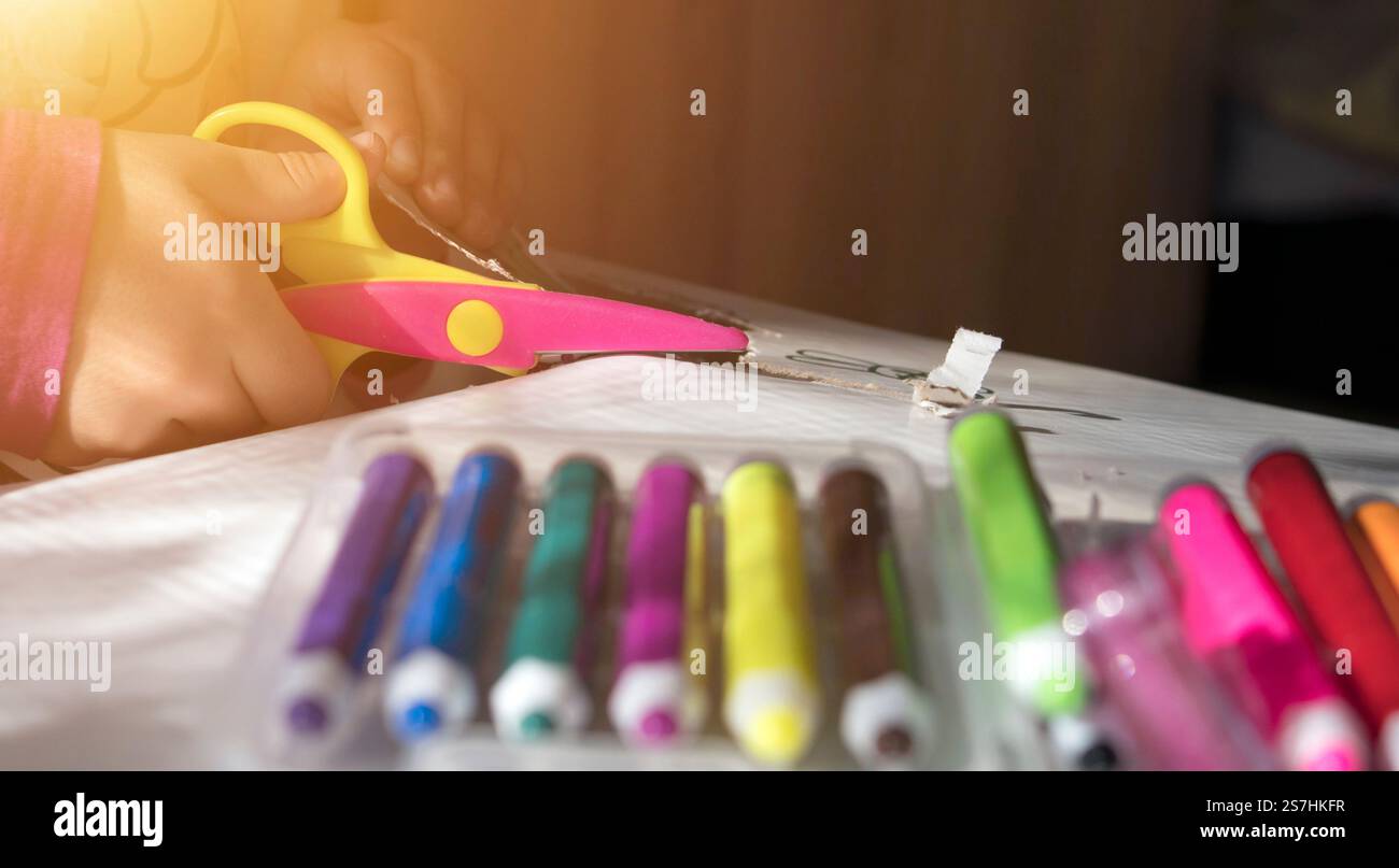 Child's hands using scissors to cut paper. Closeup on kid crafting an ...