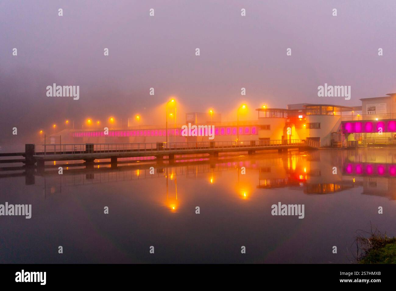 Das beleuchtete Stauwehr des Baldeneysee in Essen, bei starken Nebel ...