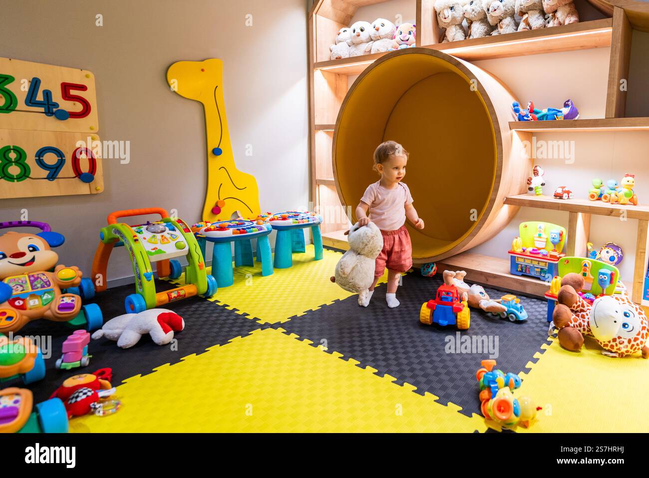 Young child playing in vibrant daycare play area filled with ...