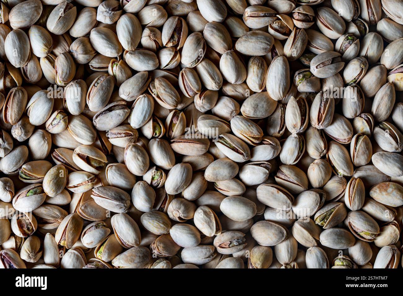 Tasty unpeeled pistachios , top view, close up. Pistachios texture and background. Pile ...